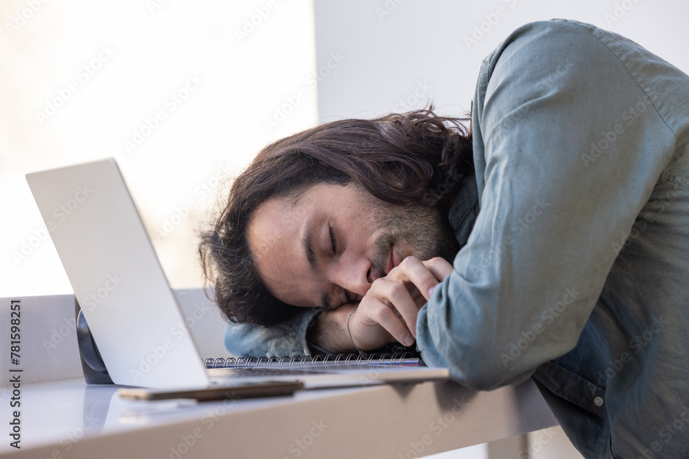 homme qui dort au bureau devant son ordinateur portable. Symbole du ...