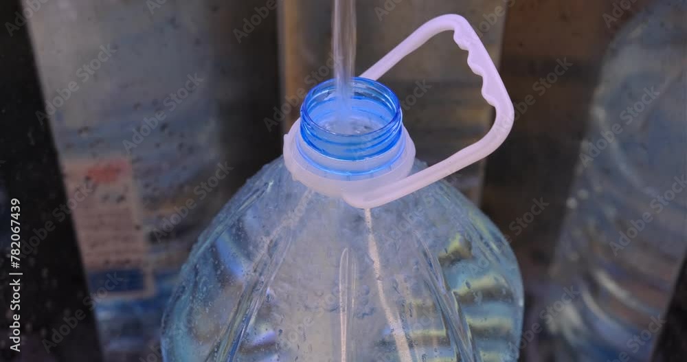 Close up of pouring water with 5 litre plastic water bottle at local ...