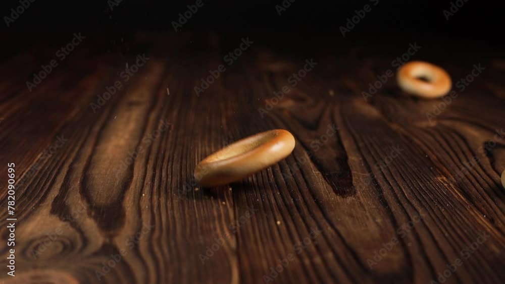 Falling bagels on a wood background. Bagels include, egg, whole grain ...