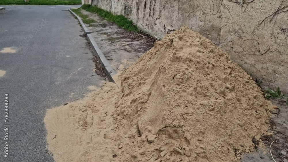 on the street lies a folded pile of sand or red clay. repair of the ...