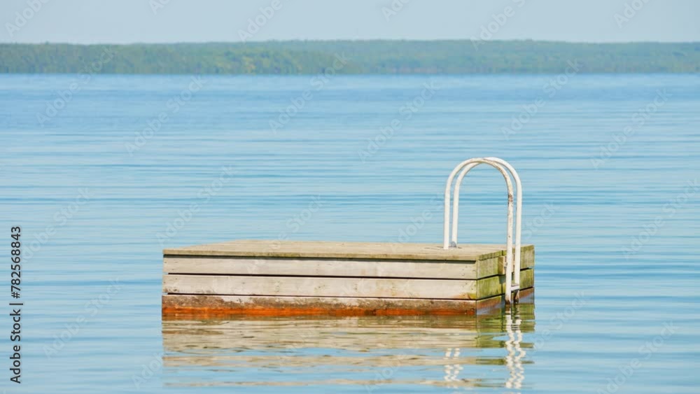 Floating swim platform in the lake, anchored in place and used for kids ...