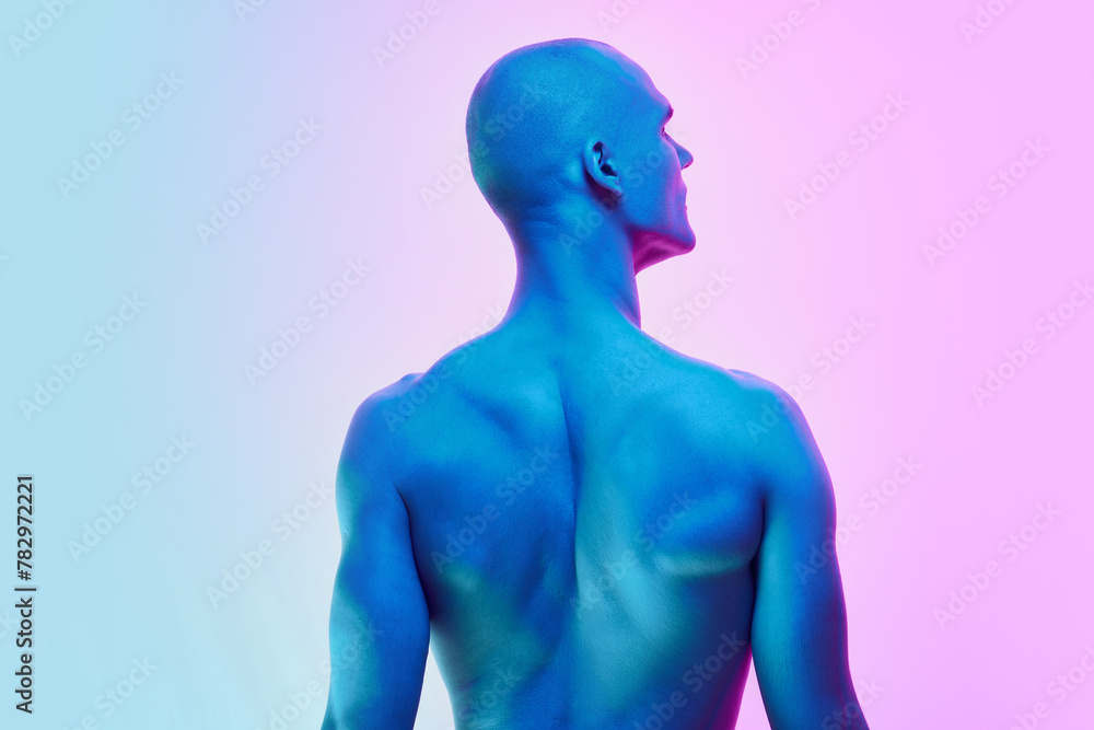 Back view of shirtless young bald man standing shirtless, showing ...