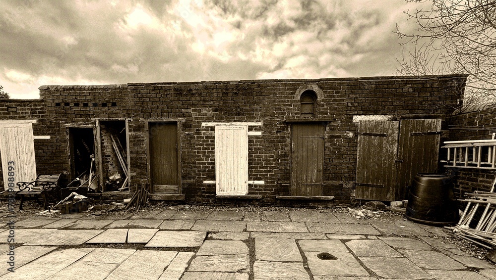 Victorian brick outhouses, with multiple wooden doors, some of which ...