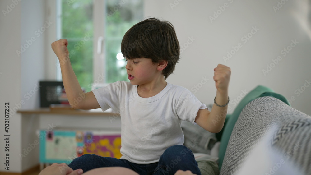 Cute 5 year old little boy flexing arms showing his strength at home ...