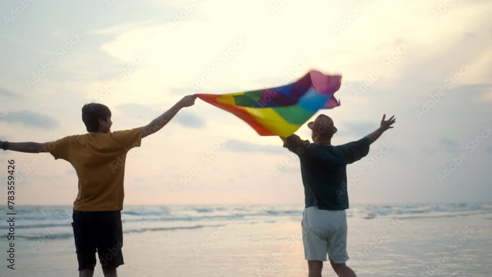 Romantic moment of bisexual gay male couple walking on the beach with ...