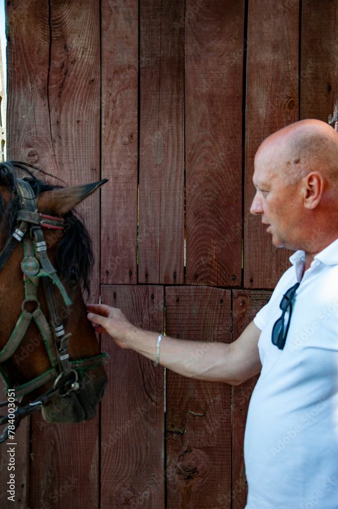 Man with horse in stable at countryside ranch. Man horse rider in ...