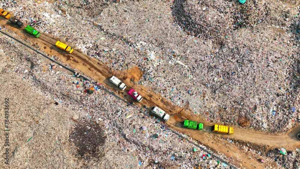 From above, a sprawling landfill sprawls like a polluted kingdom, its ...