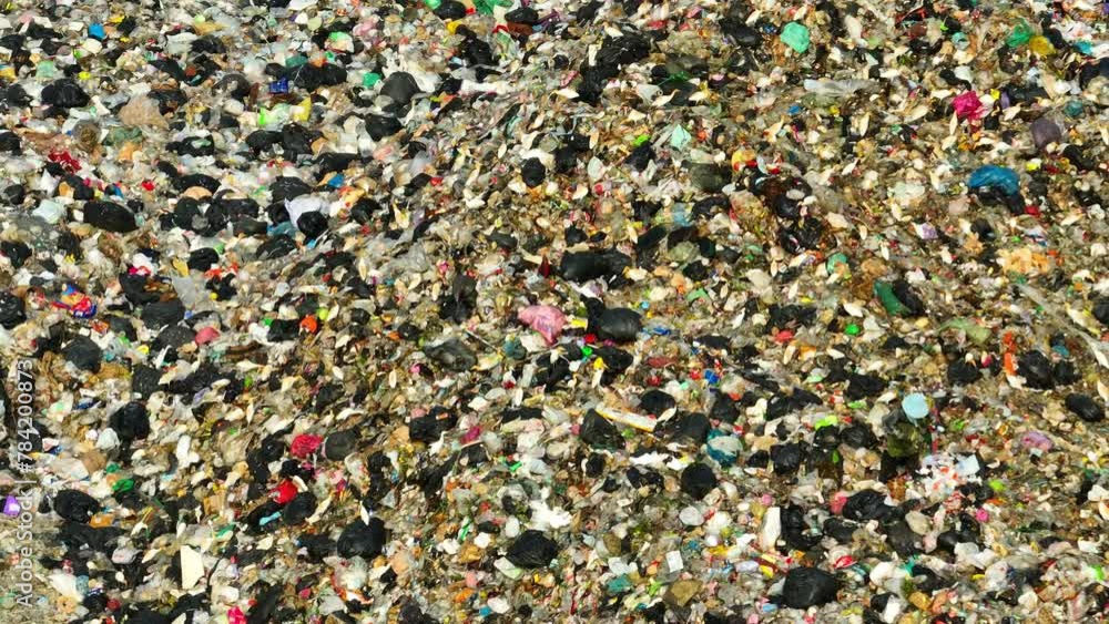 A cluttered terrain of waste, including various plastics and discarded ...