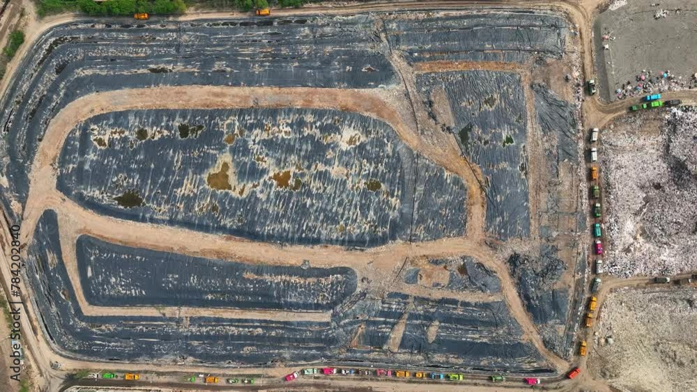 A bird's eye view uncovers a landfill veiled by layers of black plastic ...