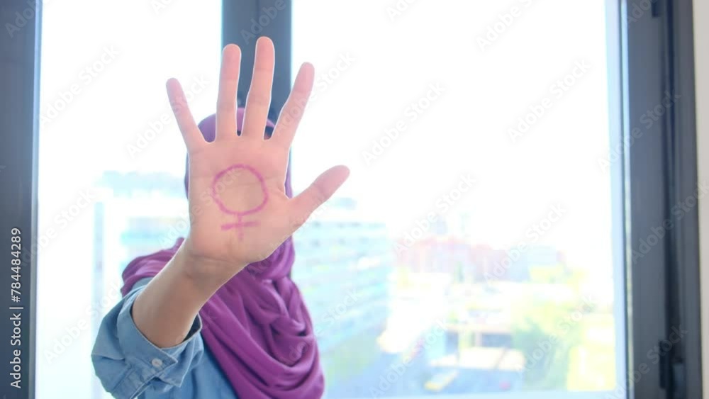 Vidéo Stock Woman with purple hijab and woman symbol on the palm of her ...