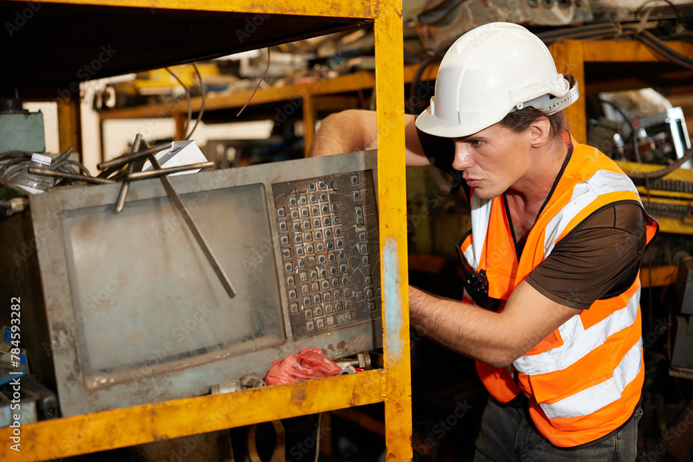 factory worker picking scrap metal on shelf in old warehouse Stock ...