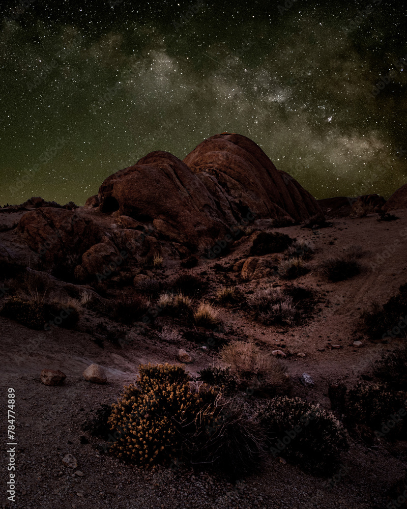 Galaxy milky way surrounded by stars with piles of rocks on foreground ...