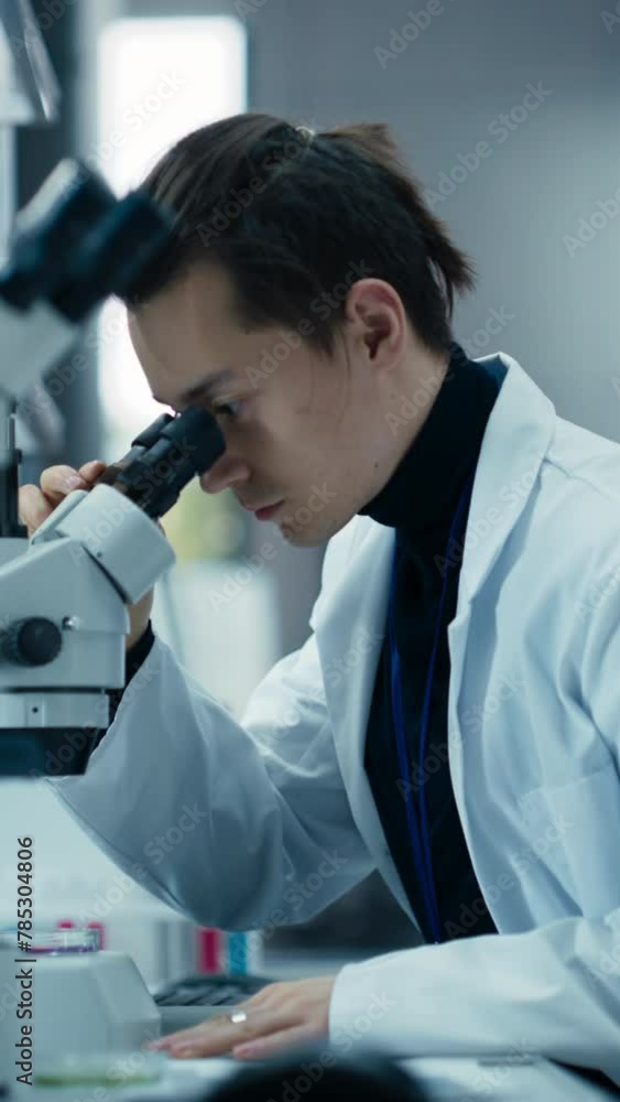 Vertical Screen: Molecular Biology Research Scientist Looking at a DNA ...