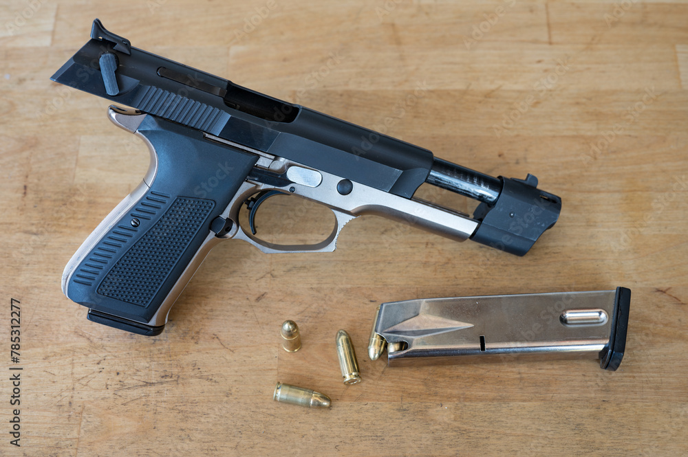 Detail of a nice open and unloaded 9mm police pistol next to a loaded ...