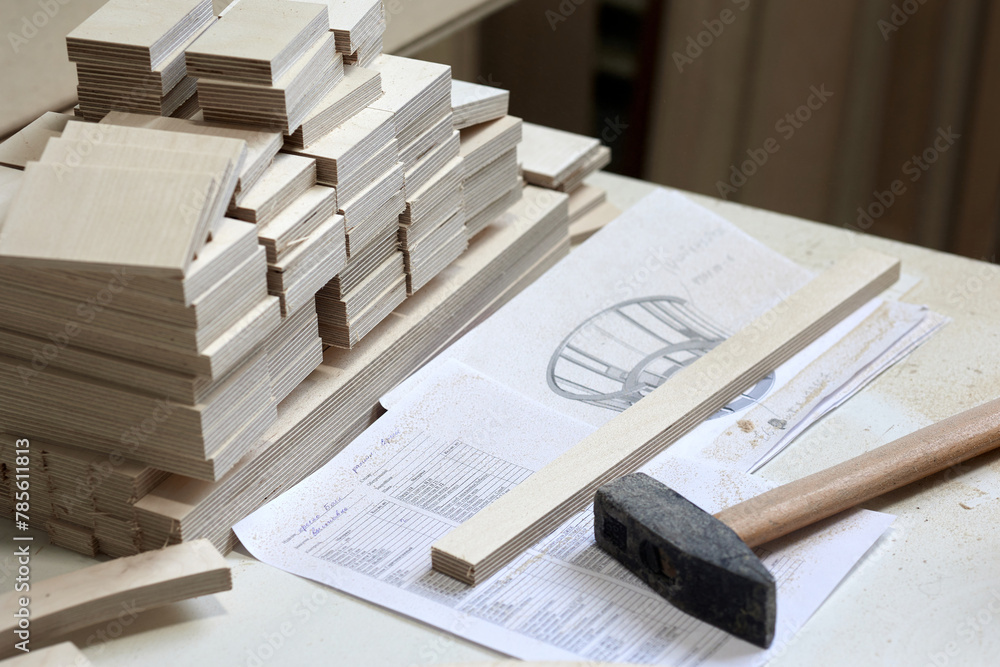 On the table are stacked small plywood blocks with an assembly diagram ...