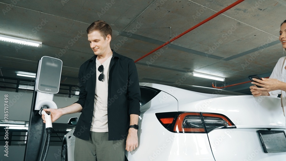Electric car driver checks battery charging status, range and charging ...