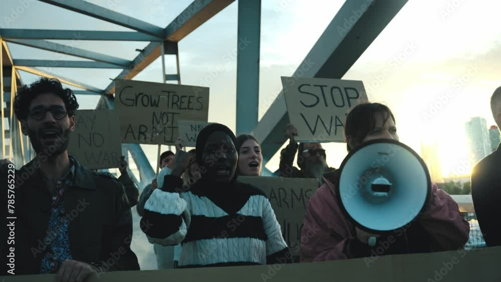 Gen z woman with megaphone in protest with diverse group activist ...