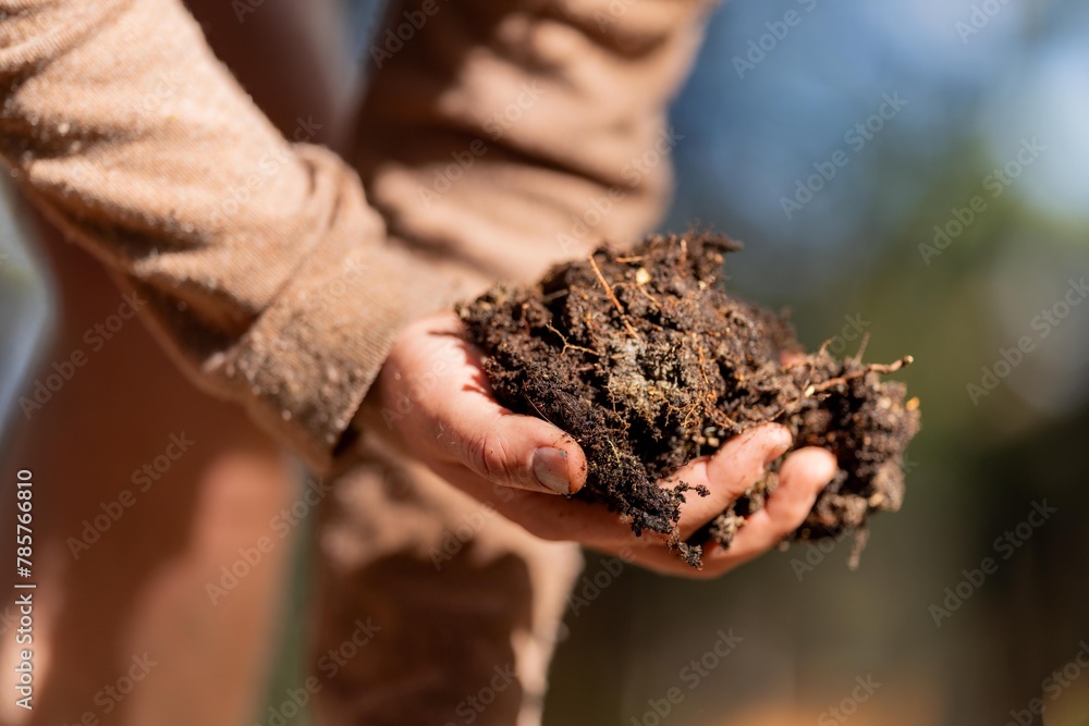 farmer holding soil in hand and pouring soil on ground. connected to ...