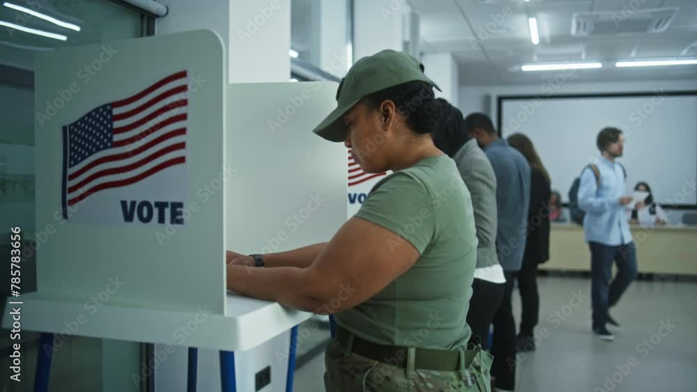 Female American army soldier votes in booth in polling station office ...