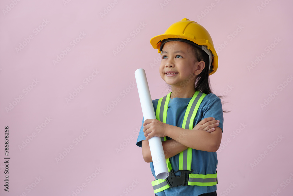 A cute girl wearing a yellow construction hat or safety helmet standing ...