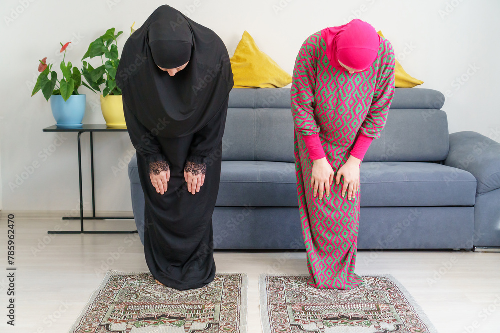 A caucasian Muslim woman in a traditional black abaya and hijab and a ...