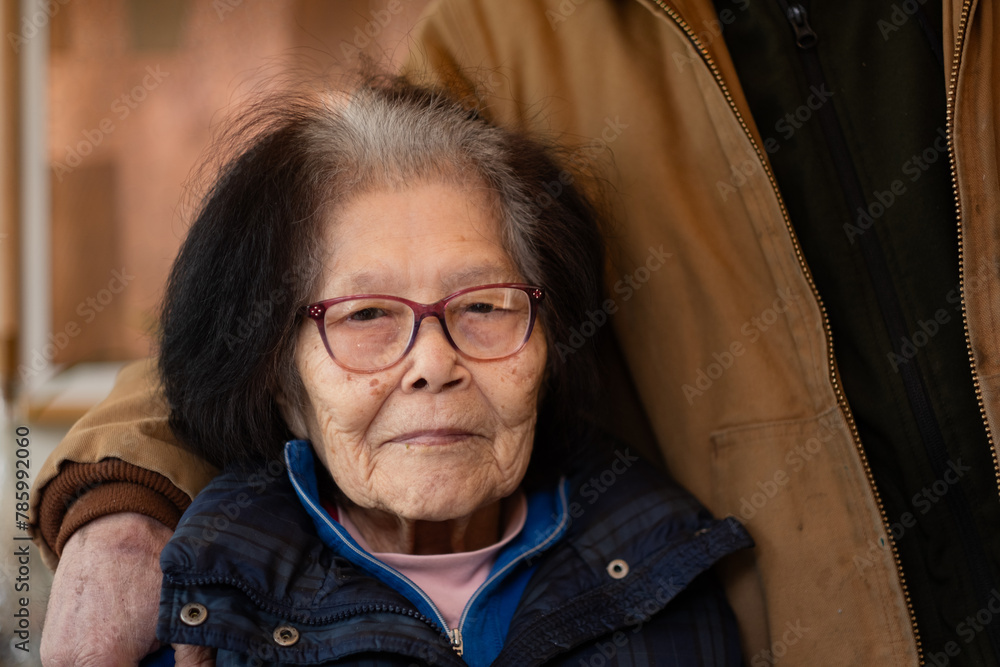 An elderly woman with dementia looks happily towards the camera with a ...