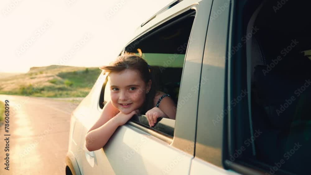 child girl face looks smiling from car out window, free girl waving her ...