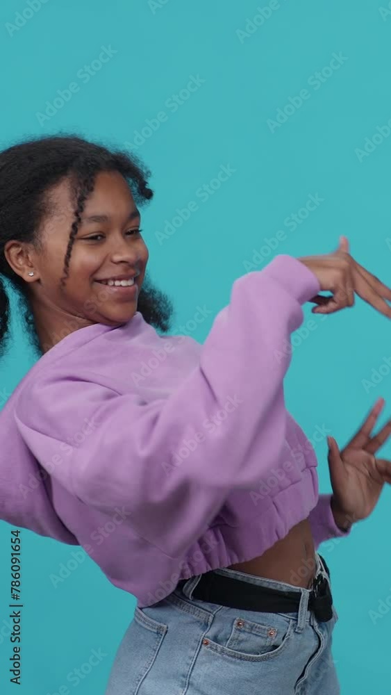 Pretty dark skinned girl dances to the music on a blue background ...