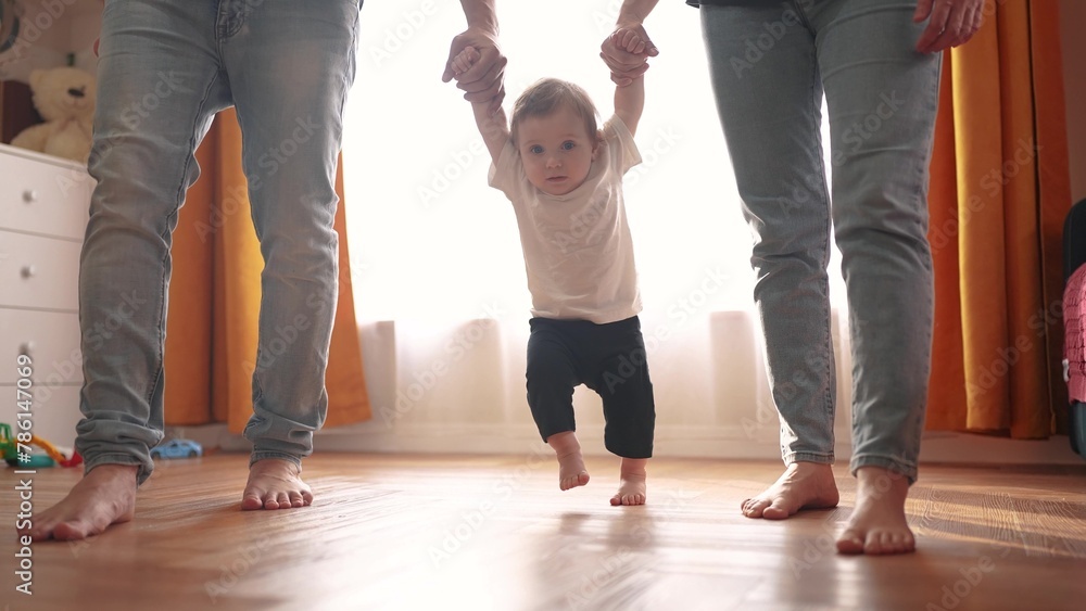 baby takes his first steps. happy family a kid dream concept. parents ...