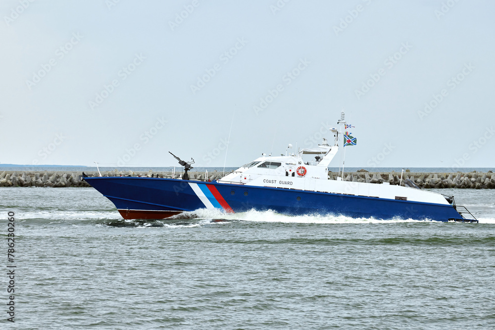 Coast guard ship sails along seaside for safeguarding coastal ...