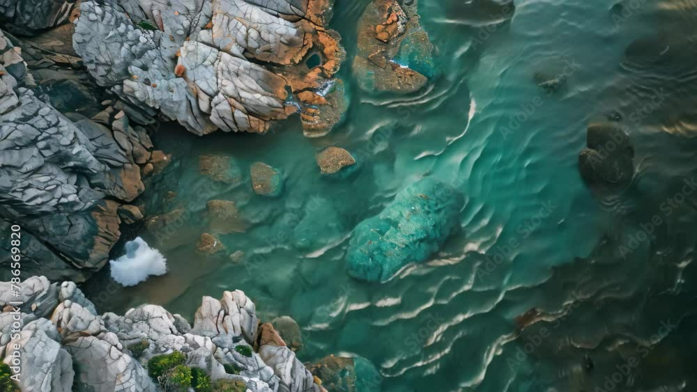This aerial photograph captures a body of water enclosed by rocky ...