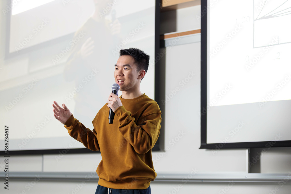 Student giving a presentation speech in front of a projector screen in ...