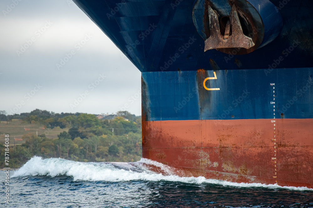 Big blue container ships bow with rusty anchors pushes a giant bow wave ...