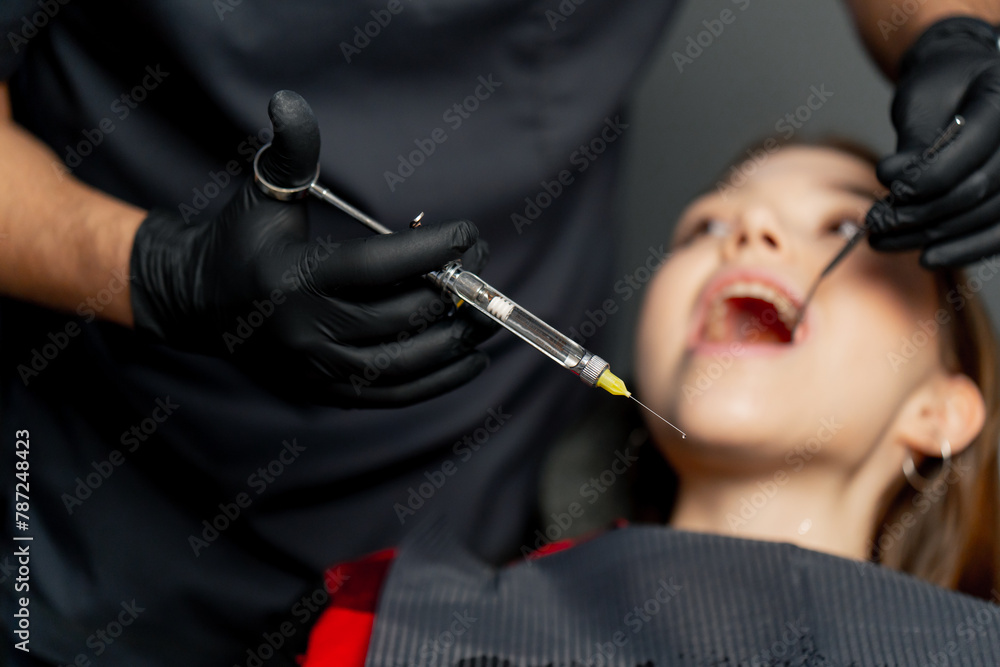 in a dental office male dentist gives an anesthetic injection to a ...