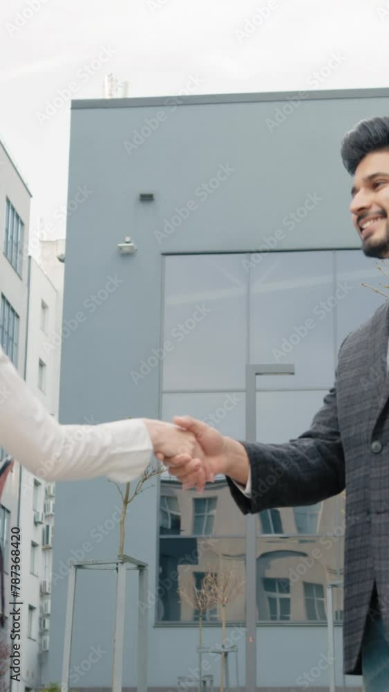 Vertical Screen: Happy arabian man and woman shaking hands after ...