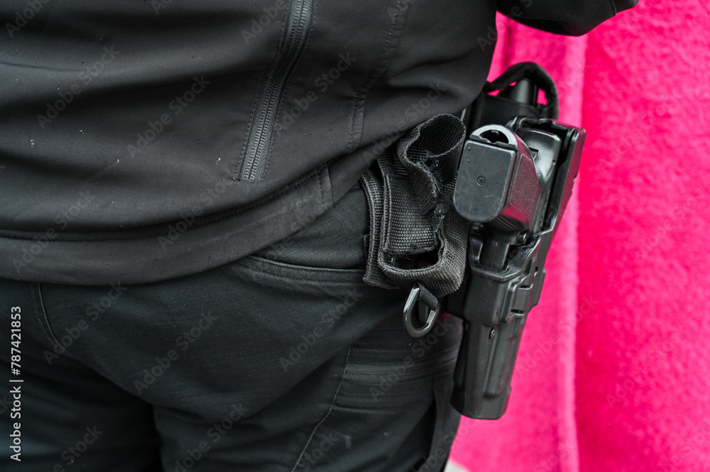 A gun on a policeman's belt. Pistol in the holster of a member of the ...