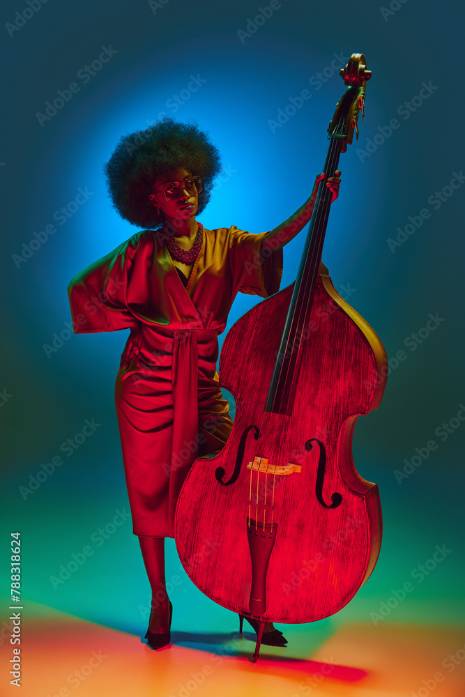 Elegant African-American woman with curly hairstyle in red dress poses ...