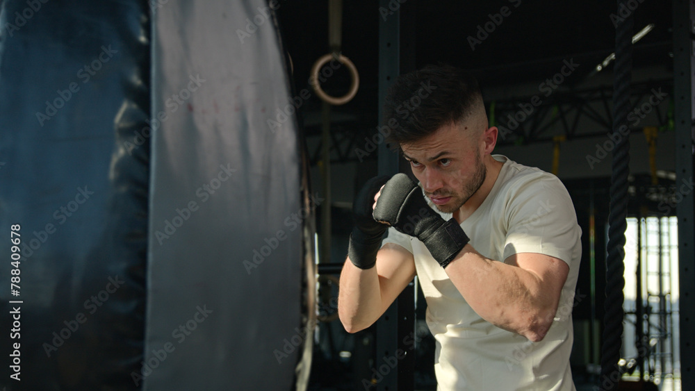 Male sportsman Caucasian man boxer training with punching bag boxing ...