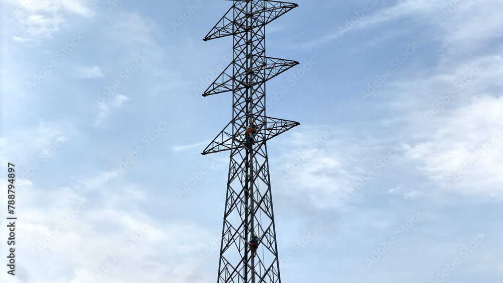 construction of electric pylons. people climbing power towers to erect ...