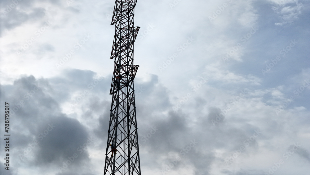Electric tower construction, workers climbing poles. dangerous ...