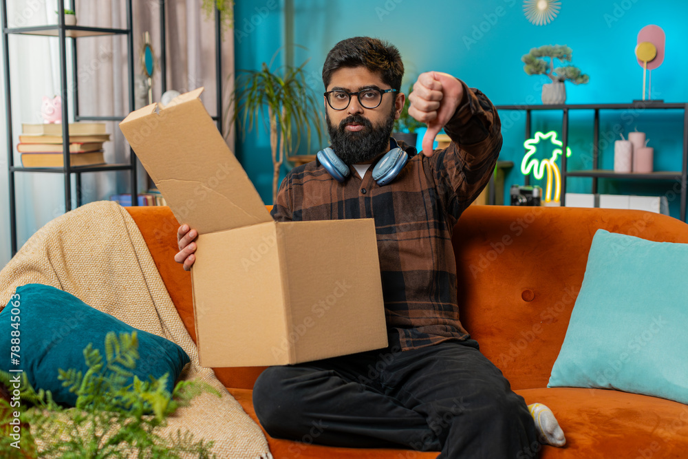Angry dissatisfied shopper Indian man unpacking parcel feeling upset ...