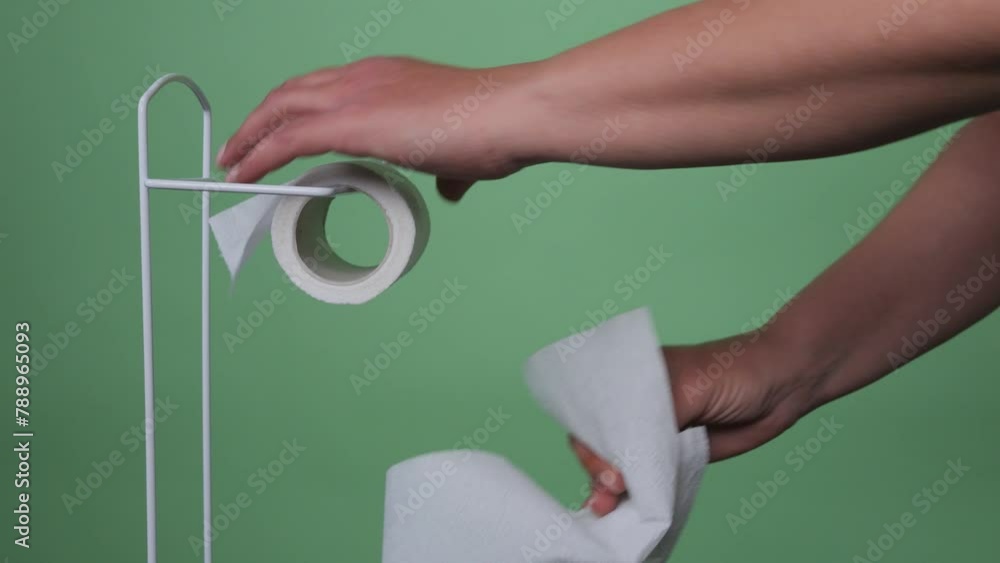 Woman Pulling And Tearing Away A Piece Of Toilet Paper From Stand Green ...