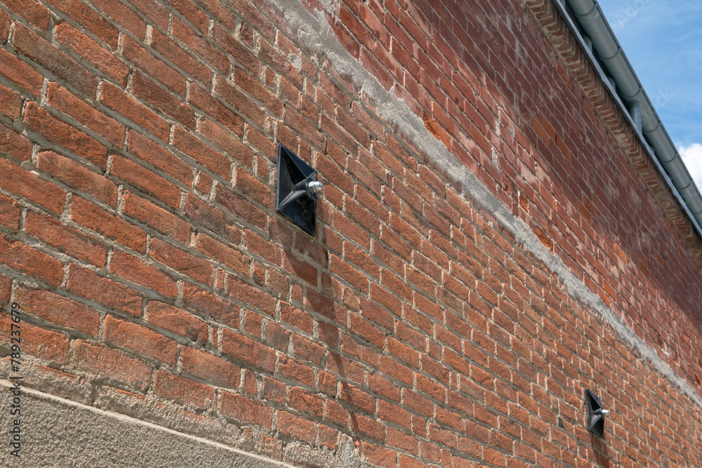 Tie rod on the wall of an exposed brick building with construction ...