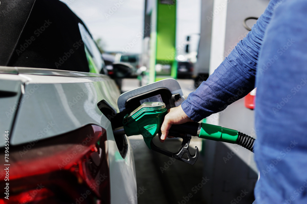 Man driver hand refilling and pumping gasoline oil the car with fuel at ...
