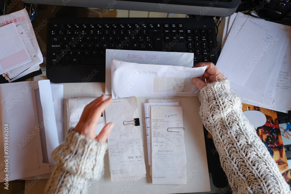Anonymous Woman organizing receipts in desk in home office Stock Photo ...