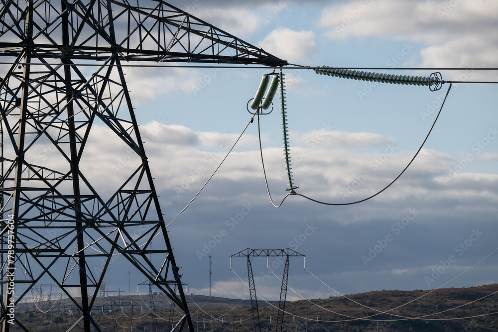 A metal electric utility pole with electrical wires, transmission lines ...