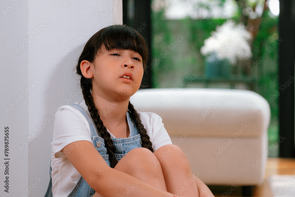 Sad little girl sitting alone in living room crying, feeling lonely ...