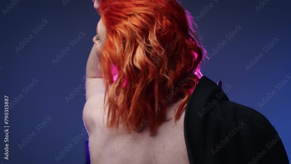 Back view of a model with red hair in front of a studio light. Artistic ...
