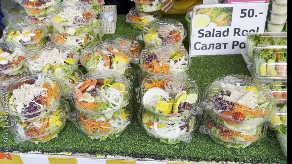 Jars of freshly made salads are lined up for sale at street food stall ...