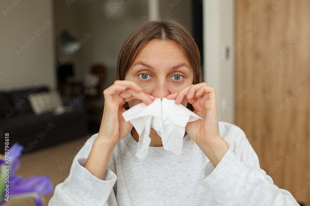 Allergy, flu, cold, rhinitis. Funny face of sick woman with paper tissues inside nose from runny ...